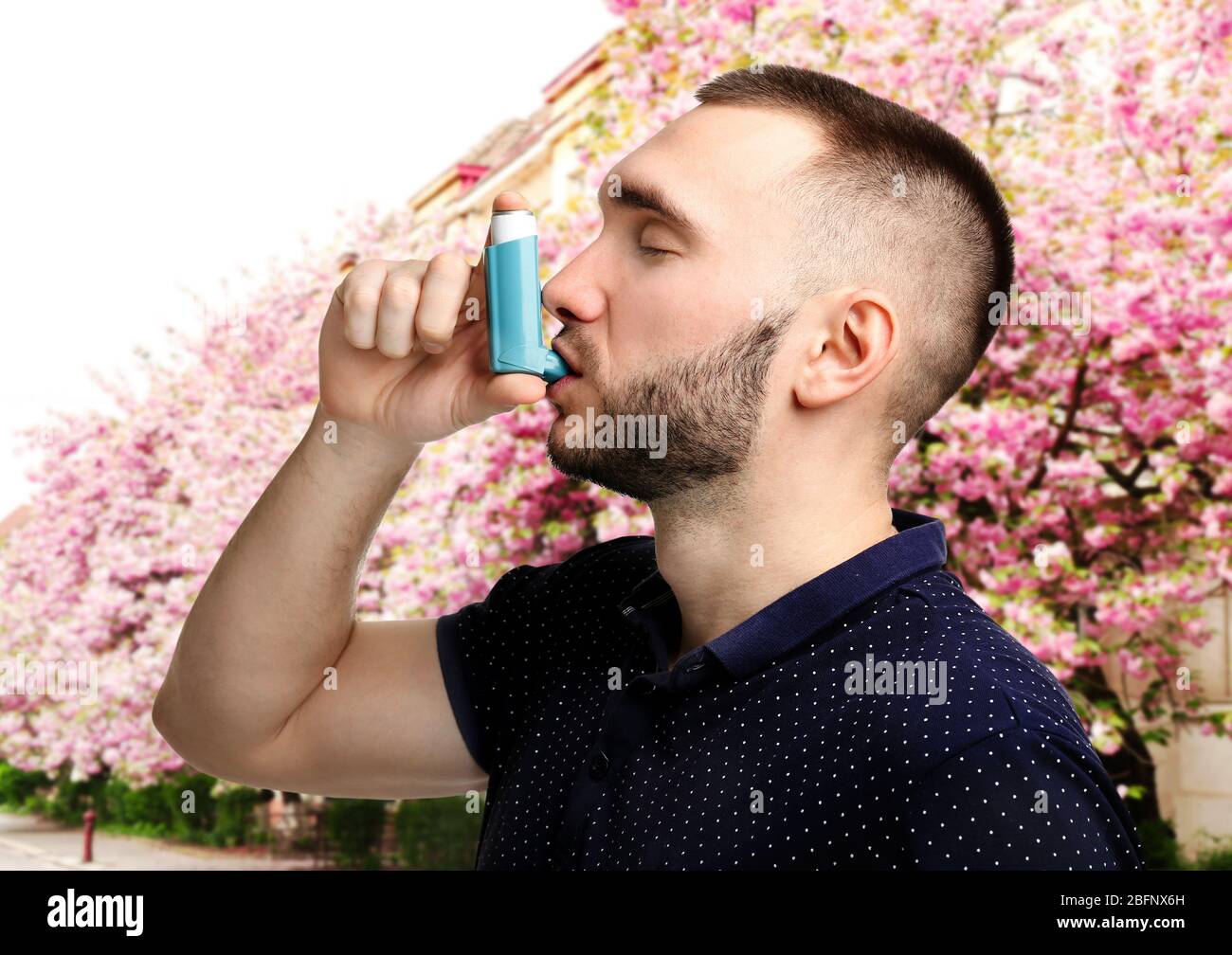 Young man using asthma inhaler outdoor Stock Photo - Alamy