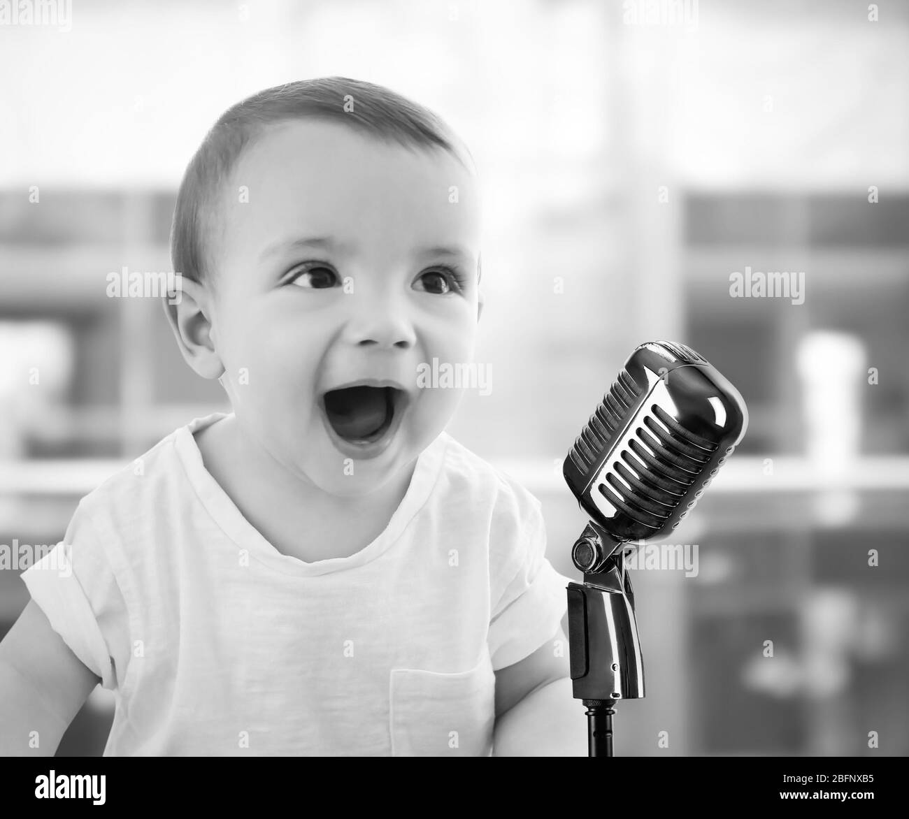Cute baby with microphone at home Stock Photo - Alamy