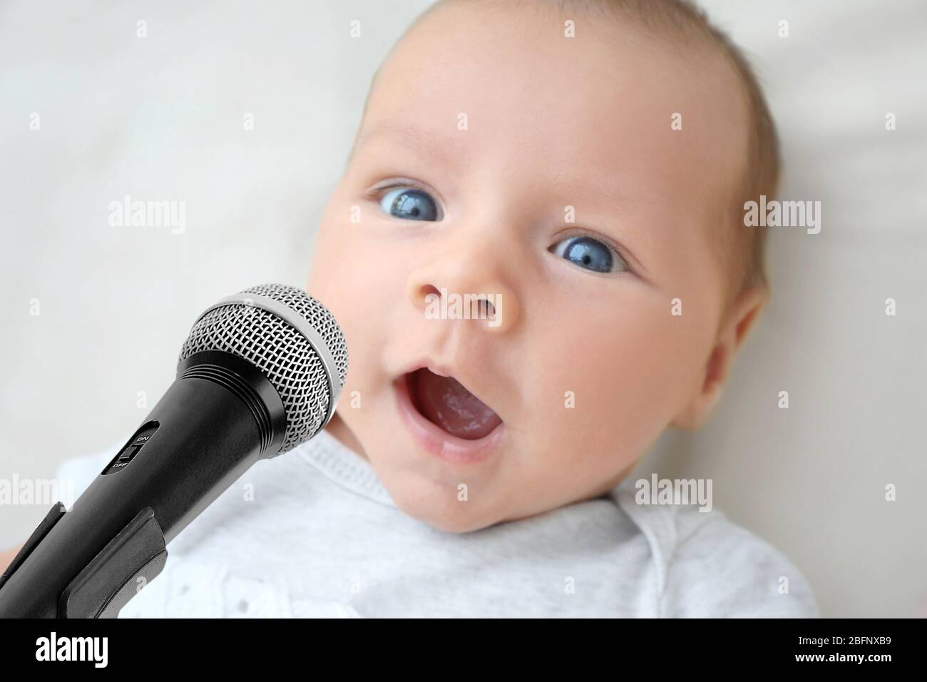 Cute baby with microphone, closeup Stock Photo - Alamy