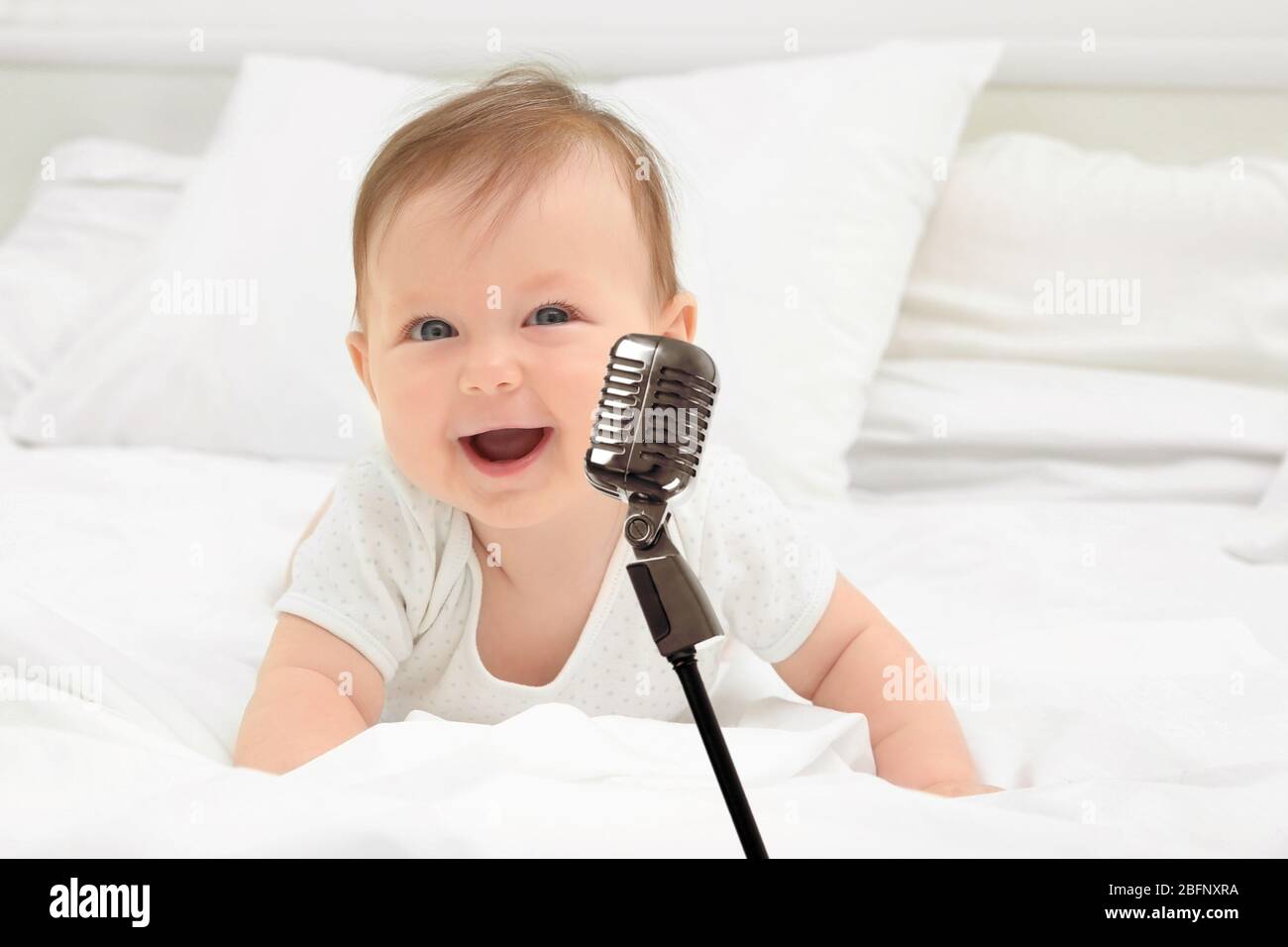 Cute baby with microphone at home Stock Photo - Alamy