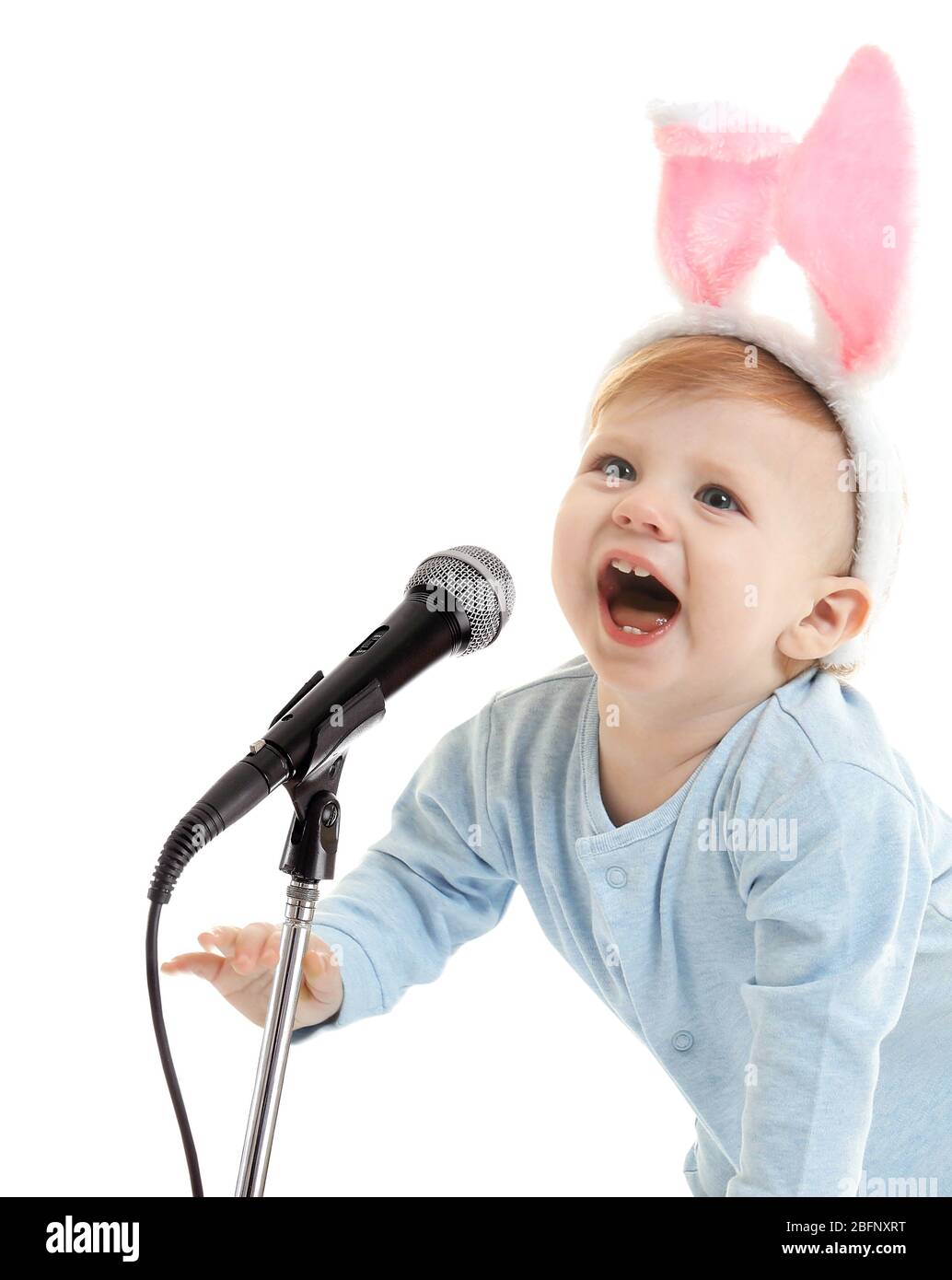 Cute baby with microphone on white background Stock Photo - Alamy