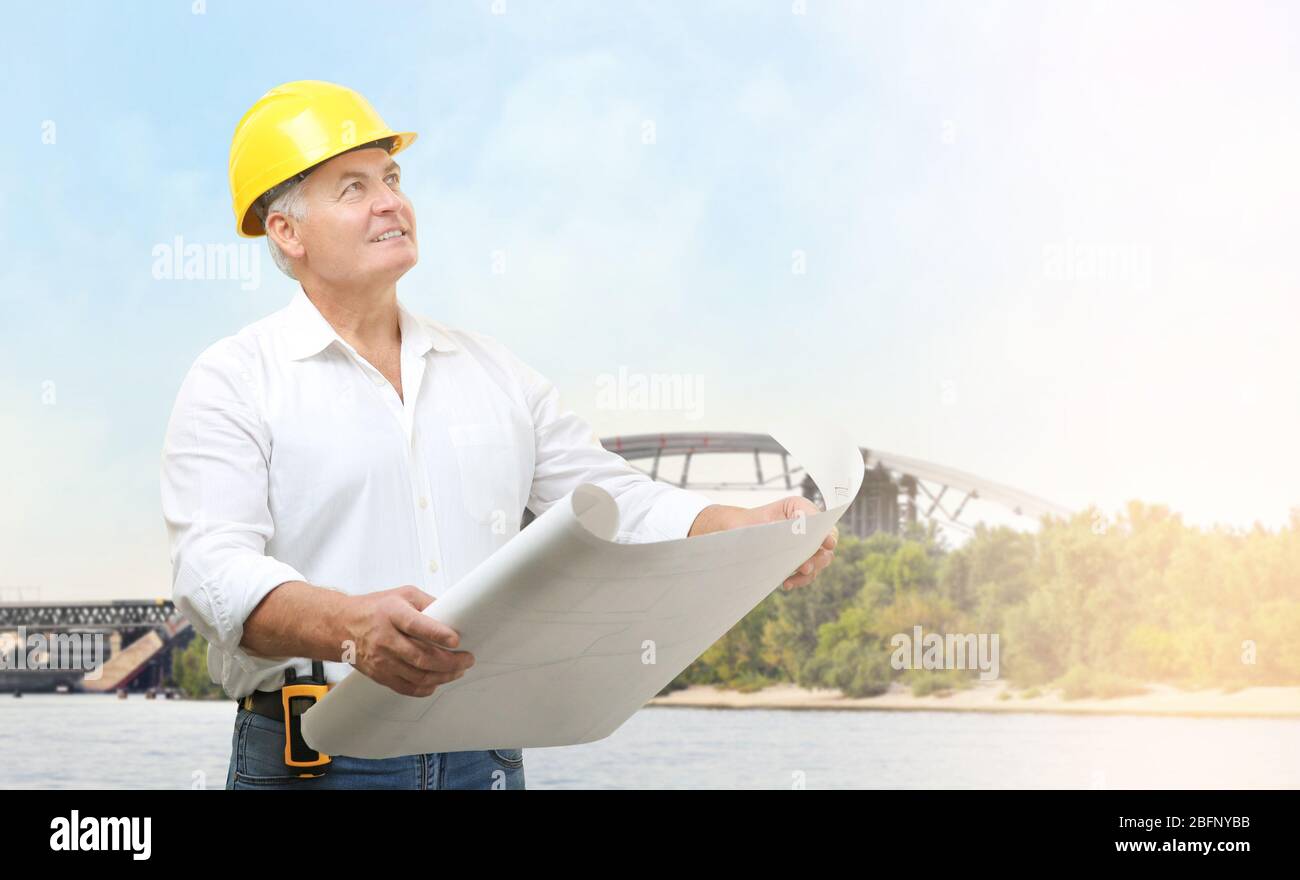 Engineer with project drawing on cityscape background Stock Photo - Alamy