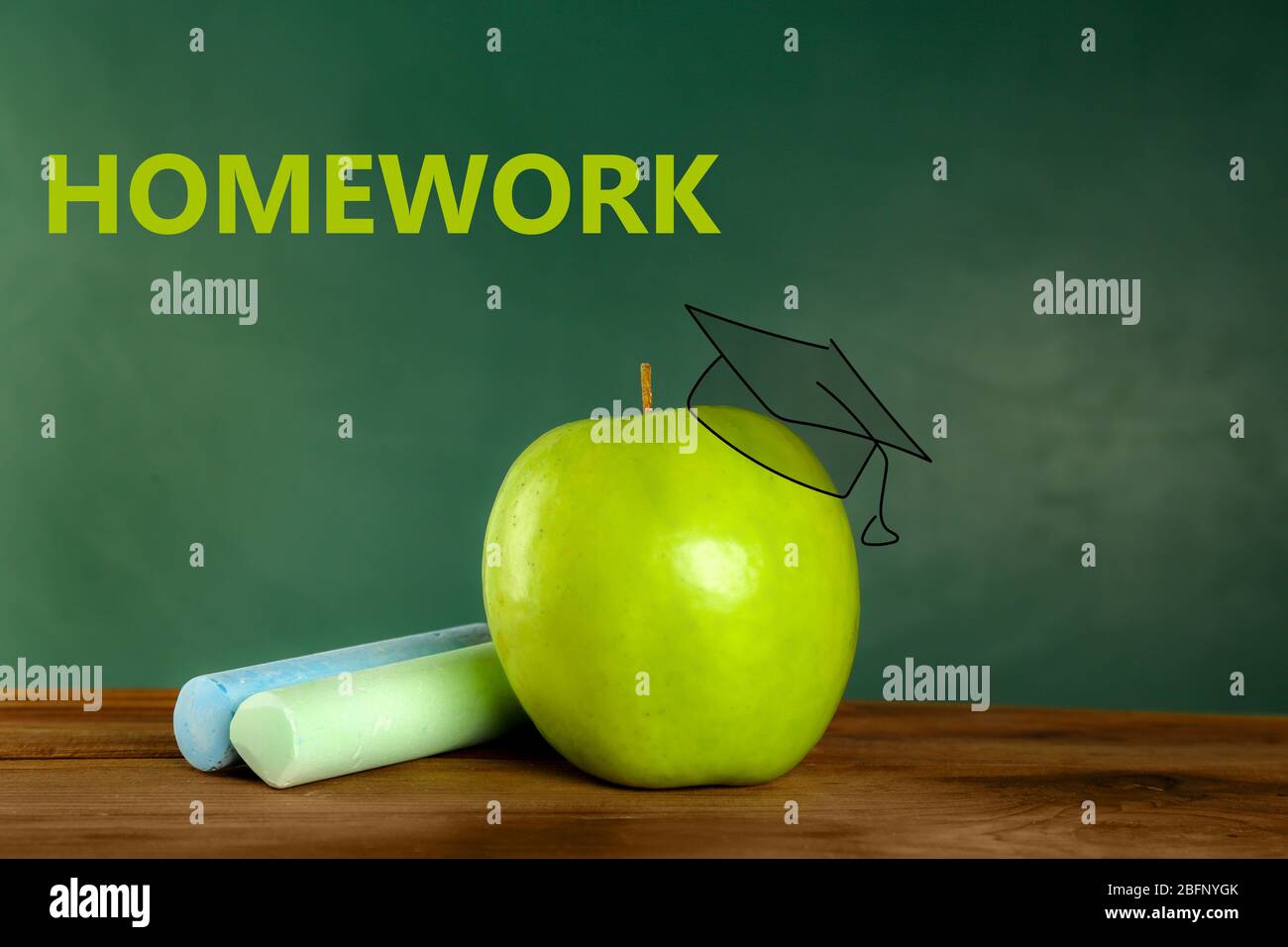 Pieces of chalk, apple with drawing of graduate cap and word HOMEWORK ...