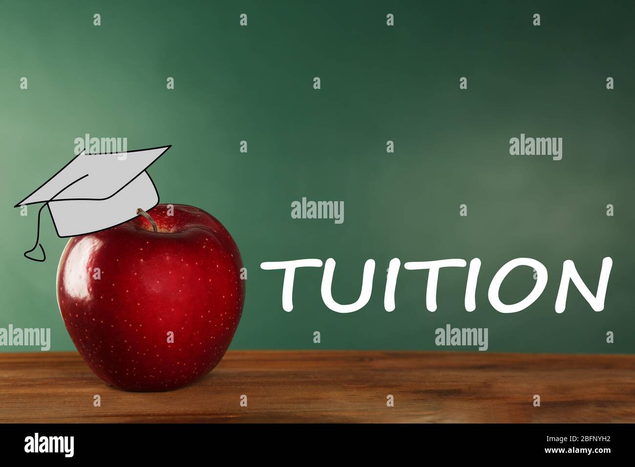 Apple with drawing of graduate cap and word TUITION on blackboard ...