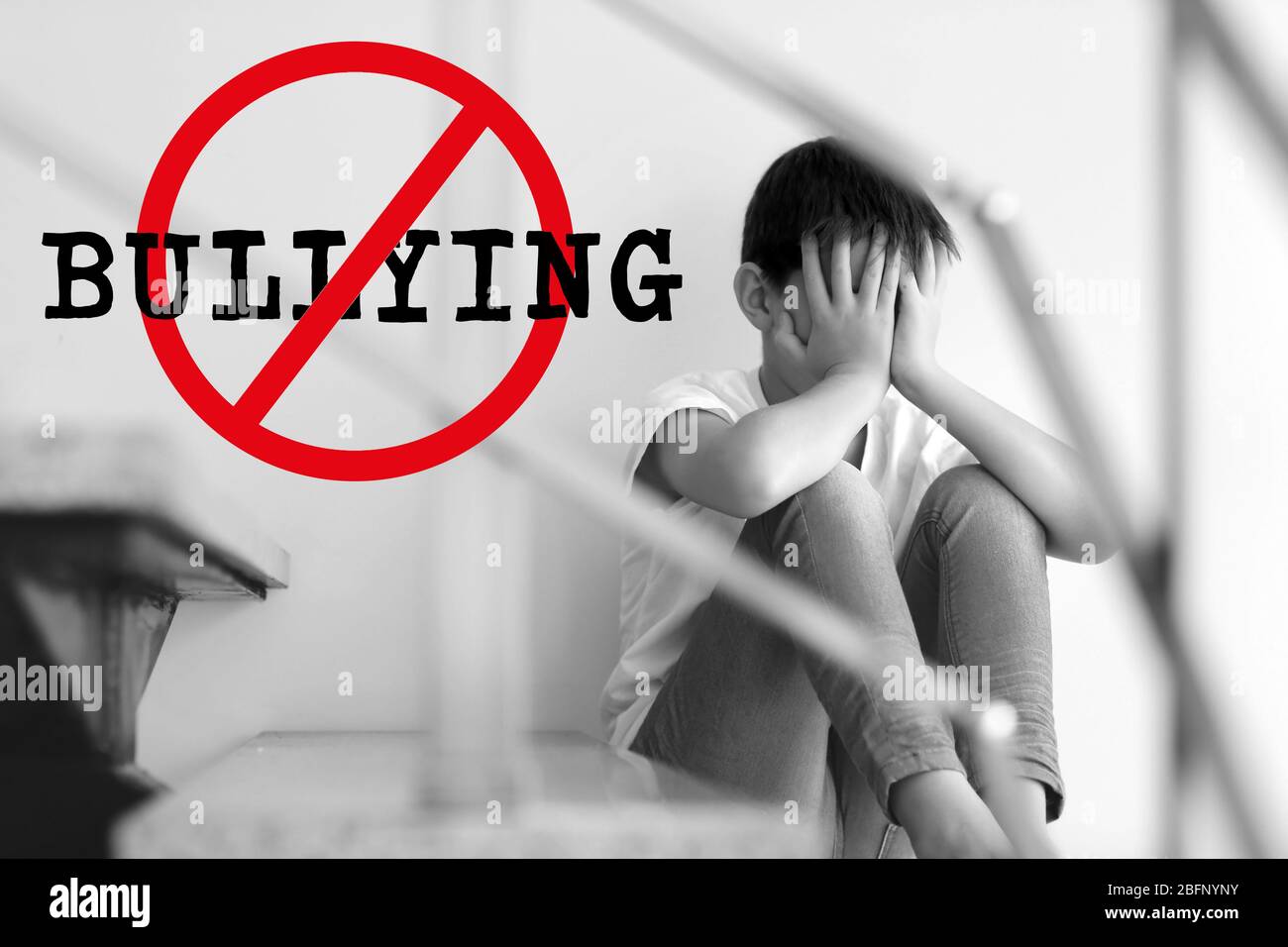 Sign STOP BULLYING and sad little boy sitting on stairs indoors, black ...