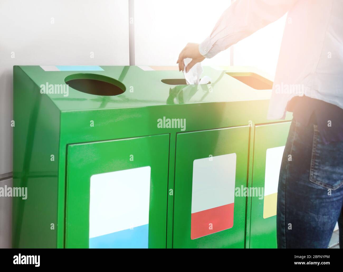 Woman throwing paper into litter bin outdoors. Recycling concept Stock ...