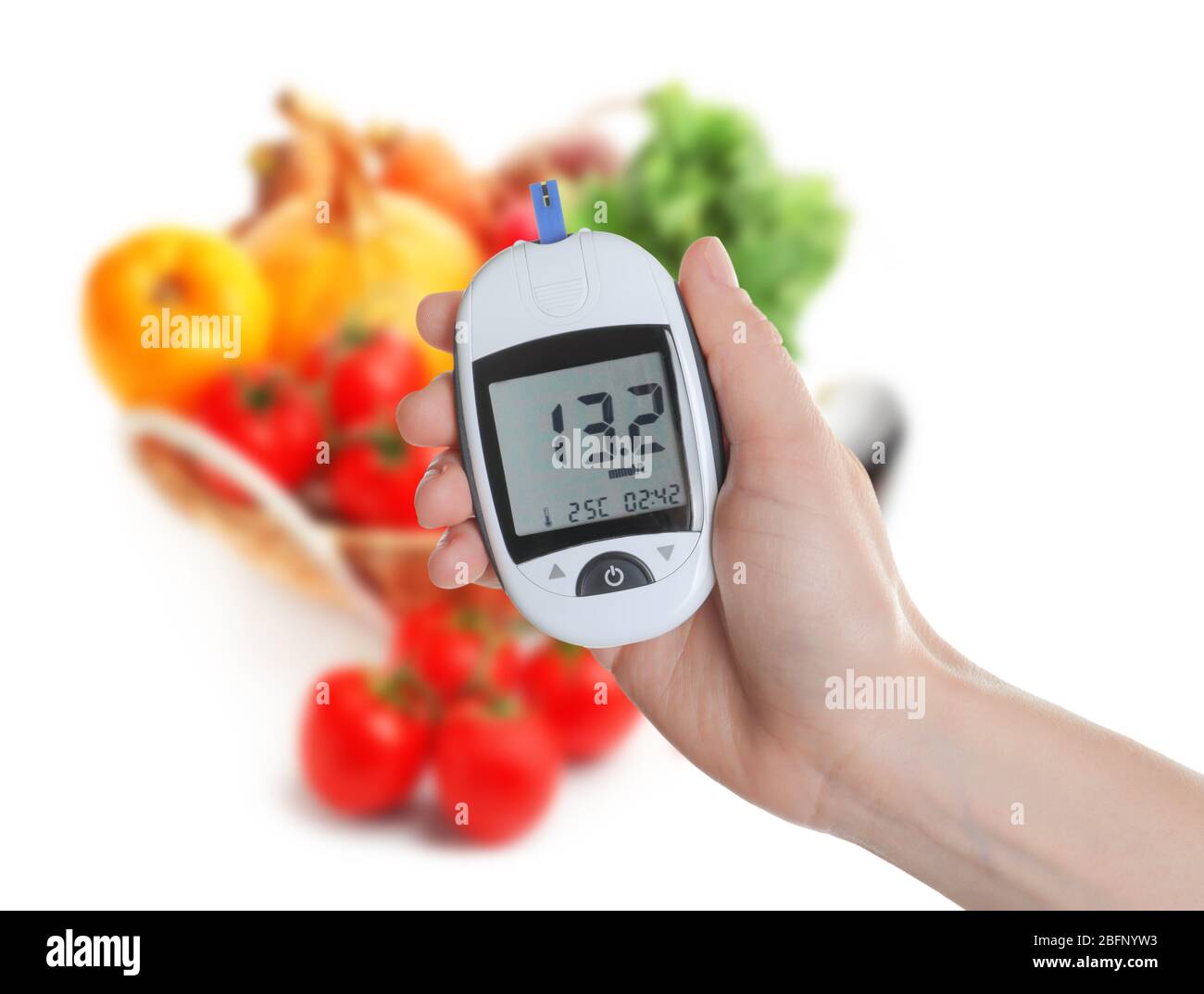 Woman holding digital glucometer and healthy food on white background ...