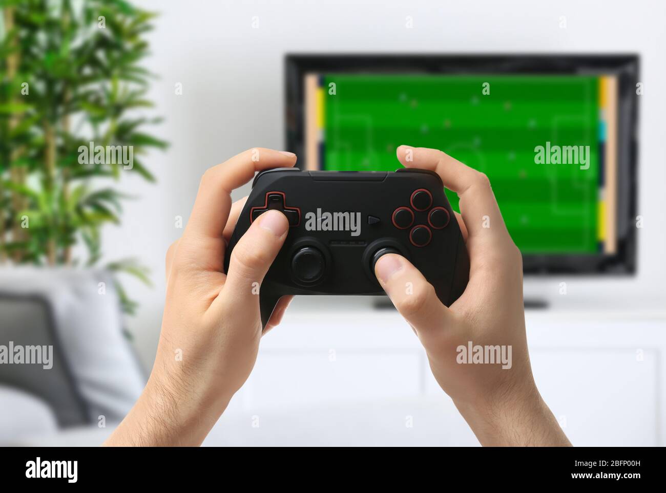 Man with controller playing video game at home. Leisure and ...