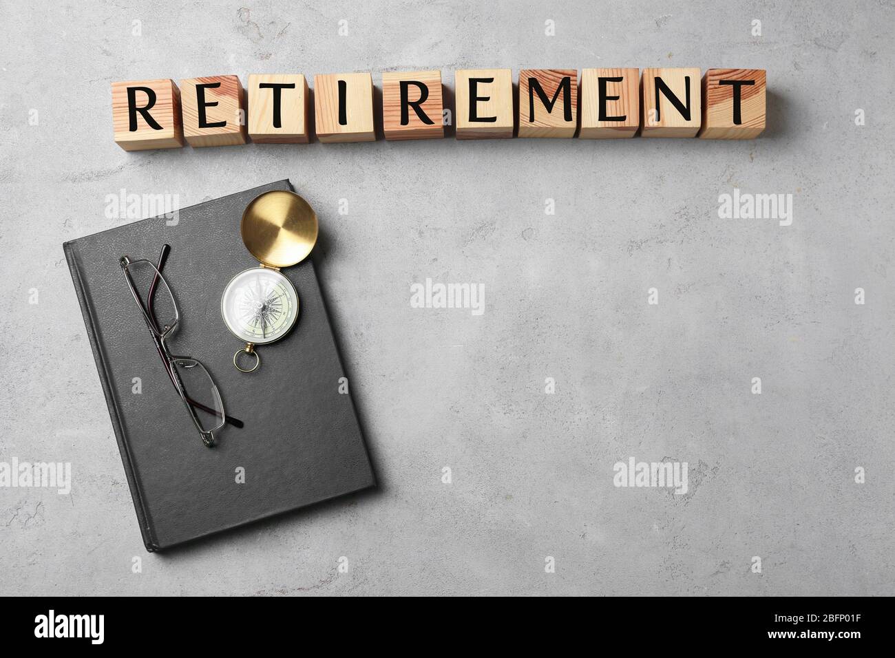Cubes with word RETIREMENT, notebook and compass on grey background ...