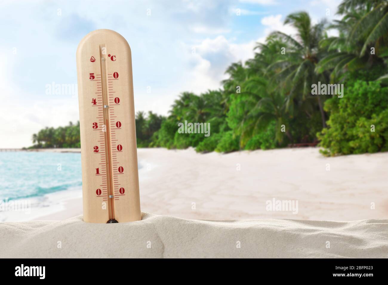 Thermometer showing high temperature on tropical beach. Hot summer ...
