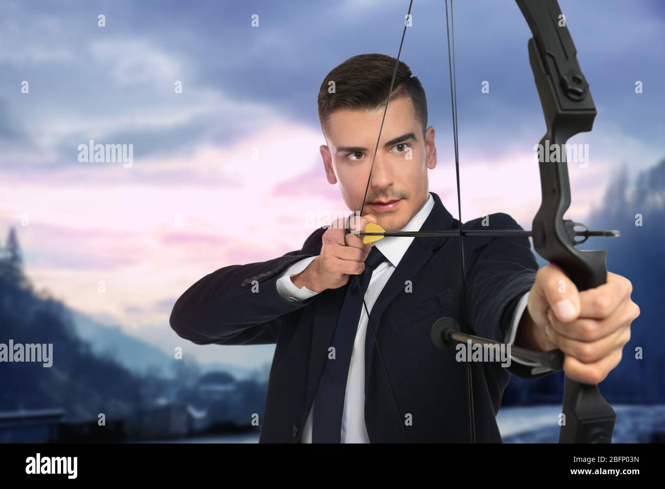 Young businessman practicing archery and landscape on background Stock ...