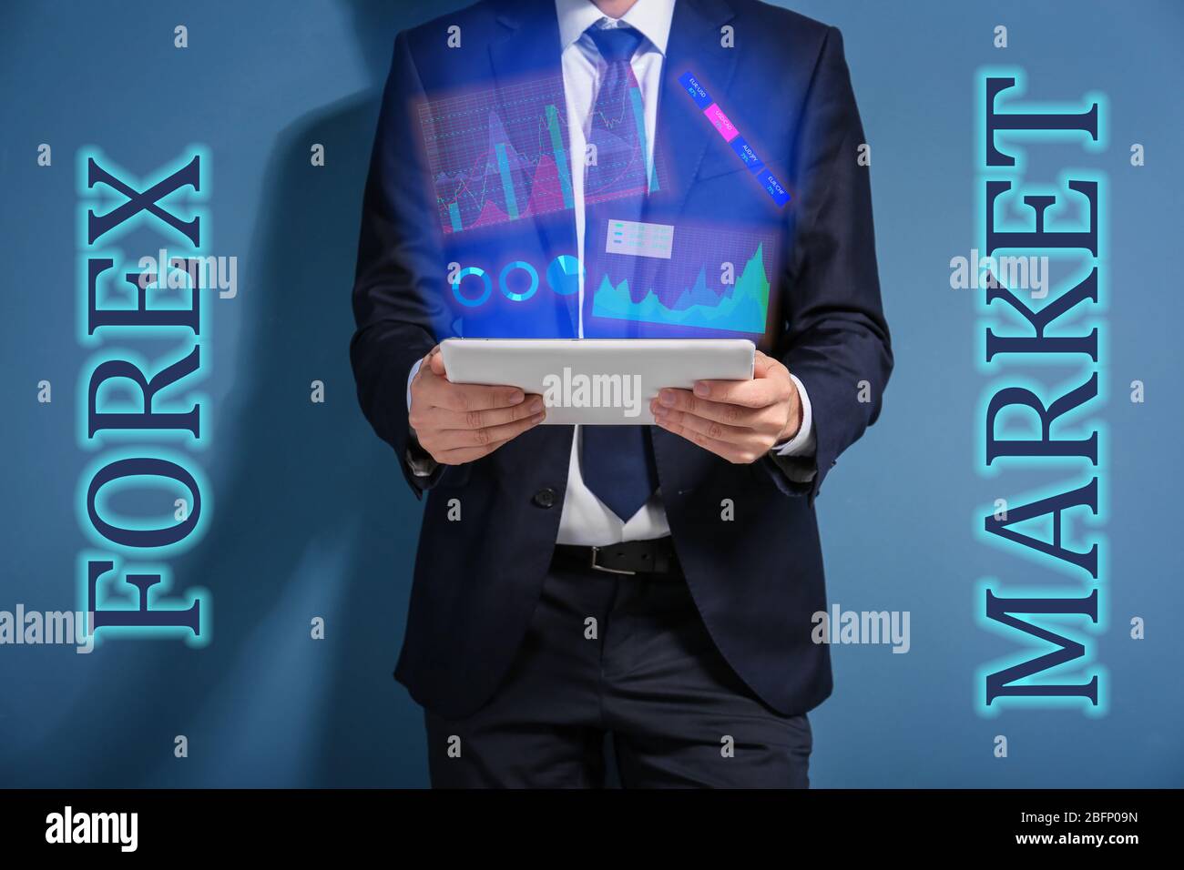 Financial trader with tablet and projections of graphs on color ...