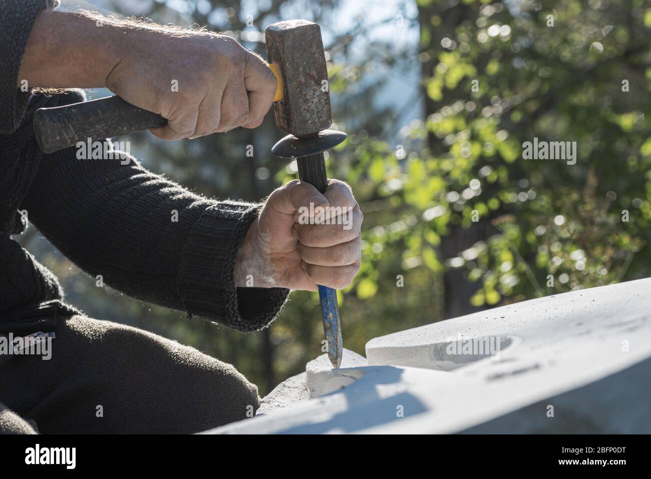 Low angle closeup view of an artist carving precise curves in white ...