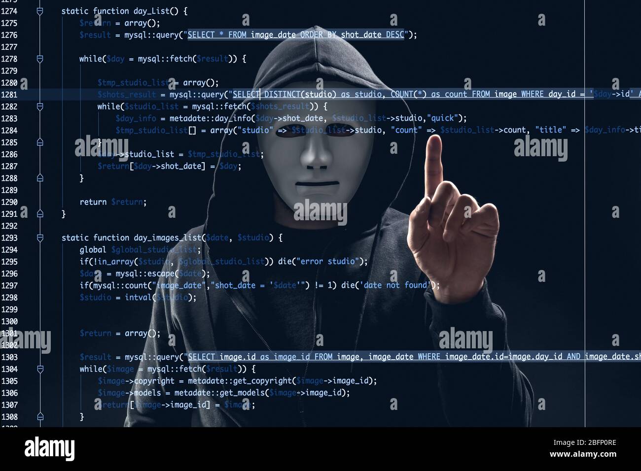 Hacker in mask working with virtual screen against dark background ...