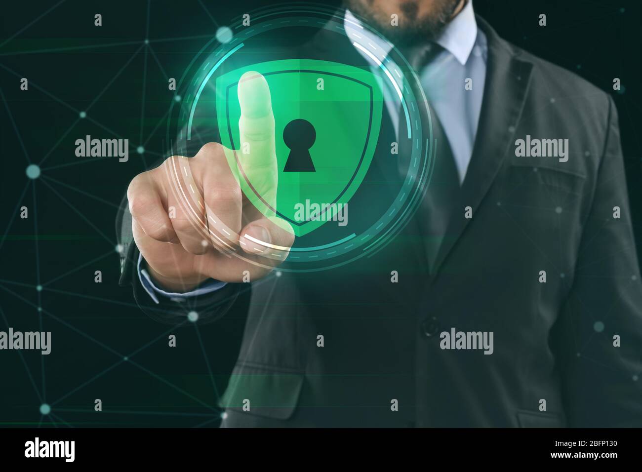 Businessman pushing button on virtual screen against dark background ...