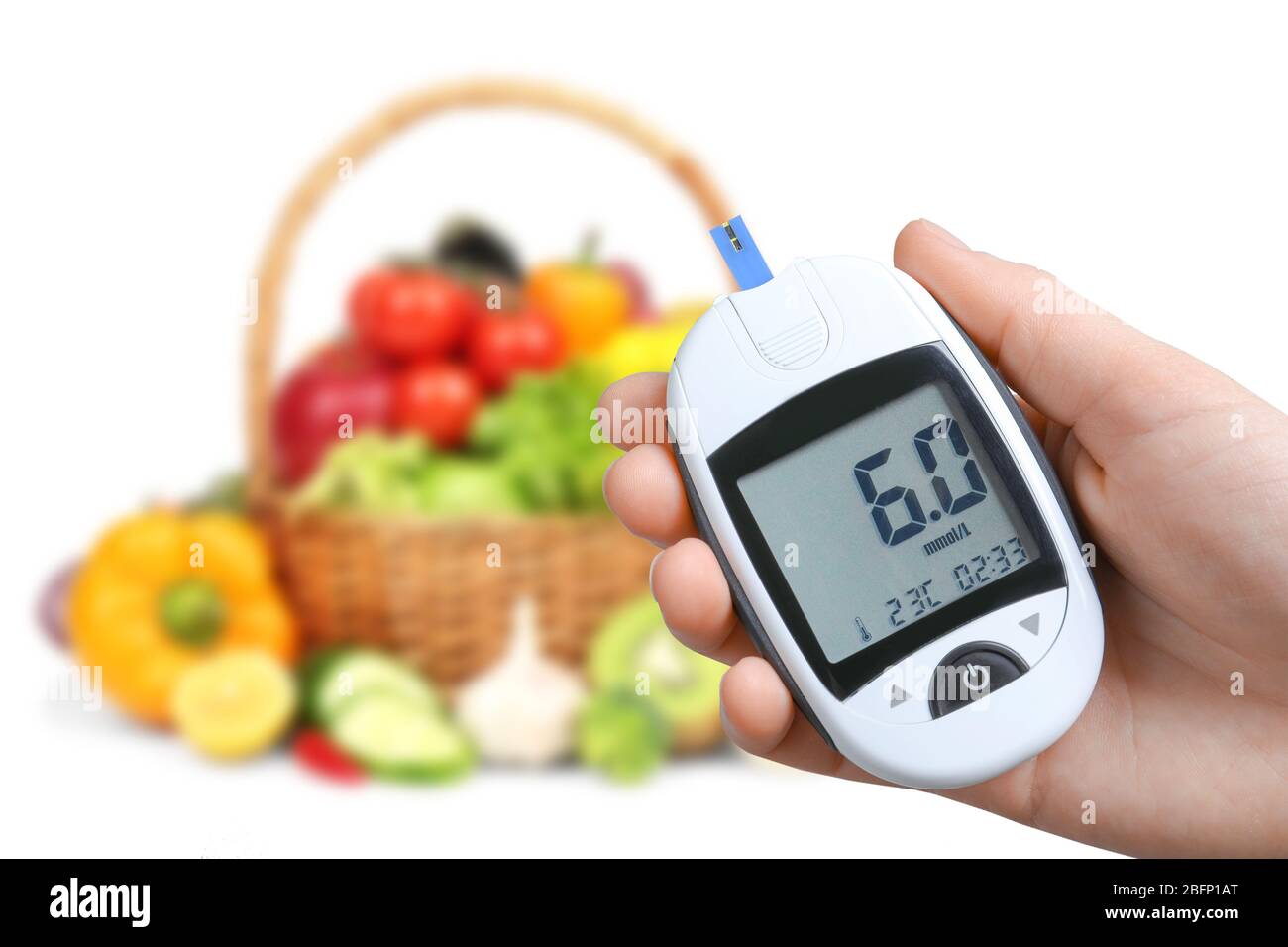 Woman holding digital glucometer and healthy food on white background ...