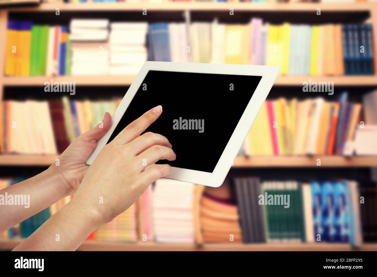 Student holding tablet-pc in library Stock Photo - Alamy