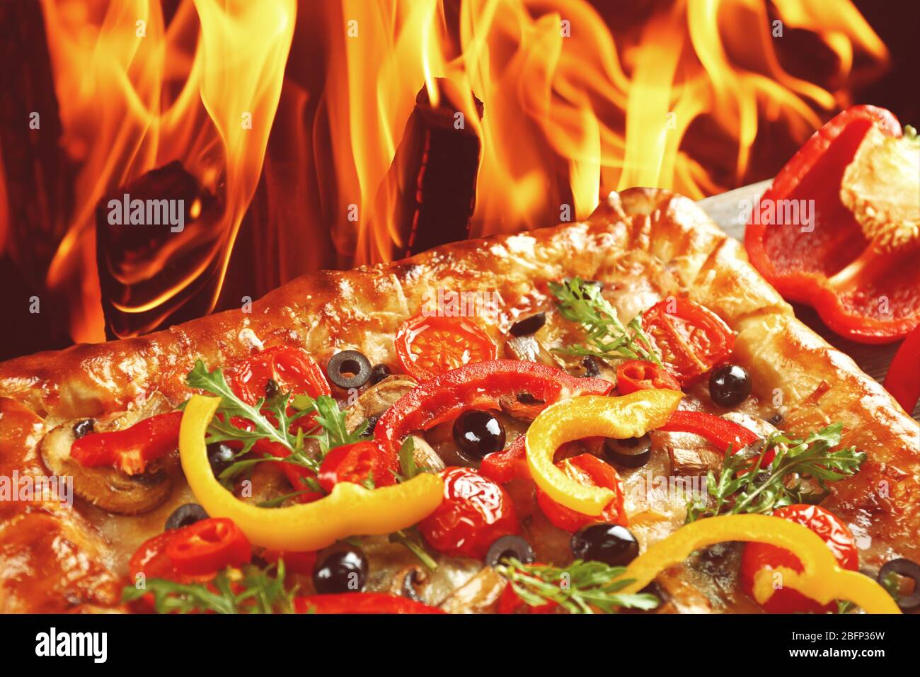 Freshly homemade pizza on fire flame background Stock Photo - Alamy