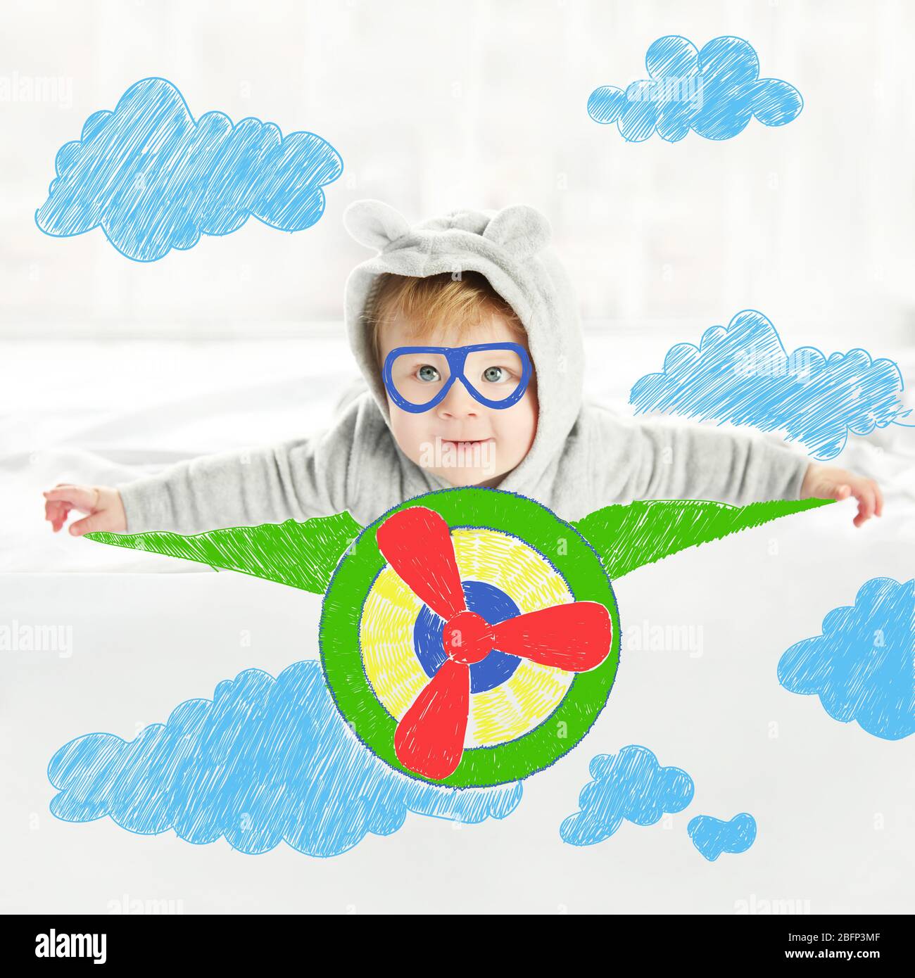 Little baby boy in grey pajamas flying on painted plane Stock Photo - Alamy