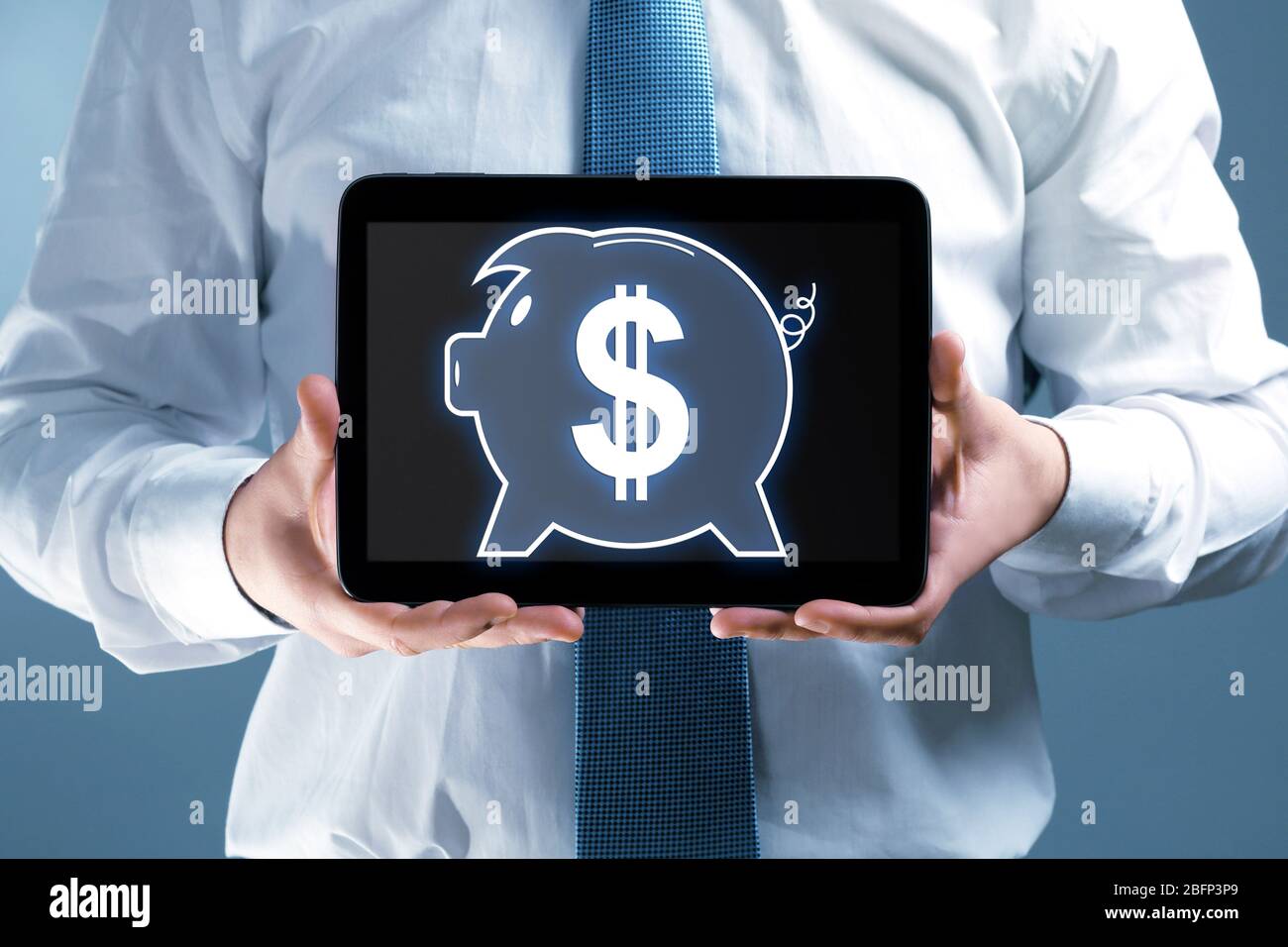 Male hands holding tablet with virtual piggy bank on screen Stock Photo ...