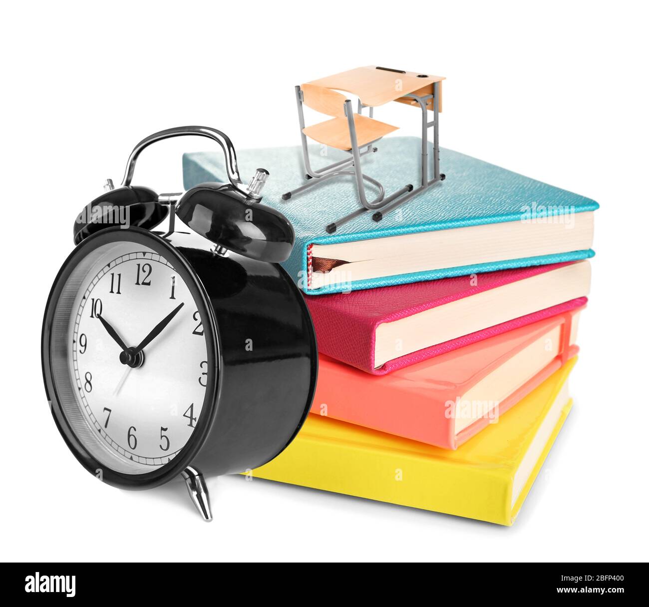 Little wooden desk and chair on colorful notebooks with alarm clock ...