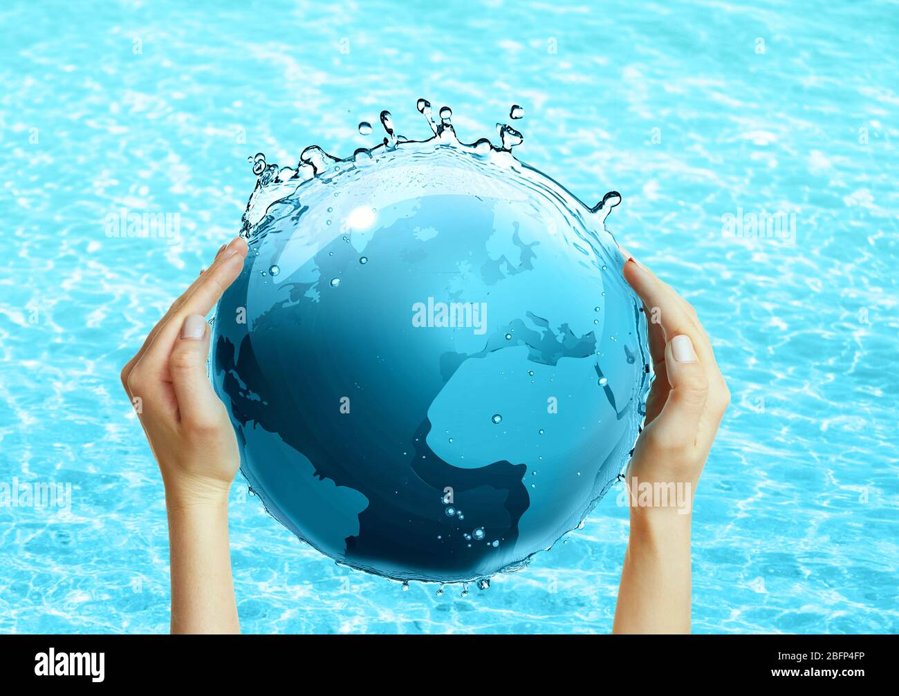 Female hands holding globe on blue water background Stock Photo - Alamy