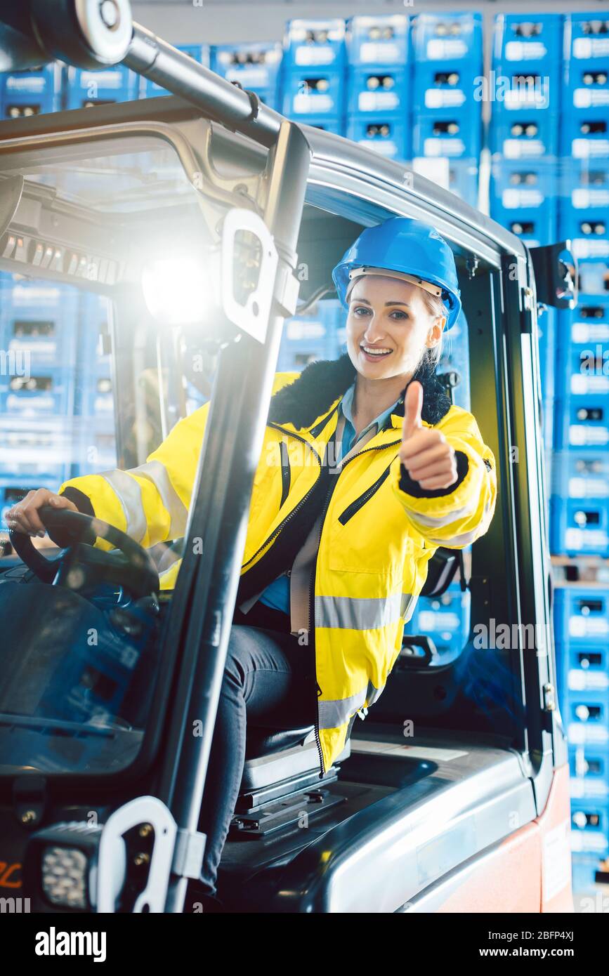 Worker woman showing thumbs up in logistics delivery center Stock Photo ...