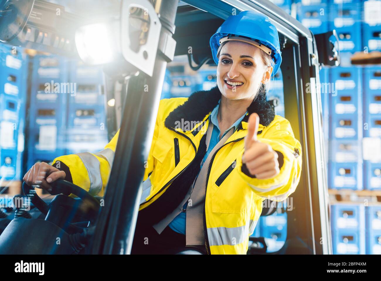 Worker woman showing thumbs up in logistics delivery center Stock Photo ...