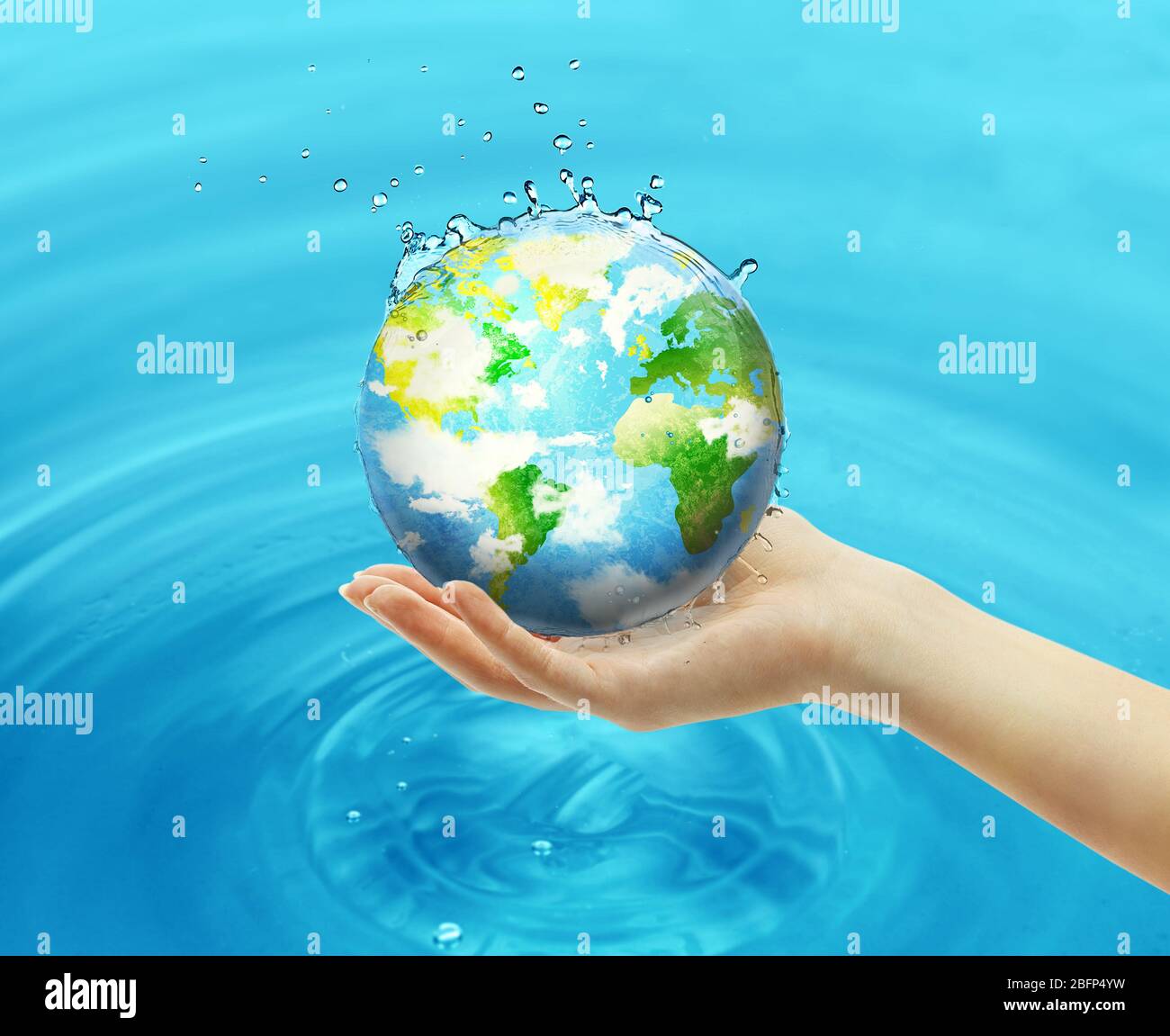 Female hand holding globe on blue water background Stock Photo - Alamy