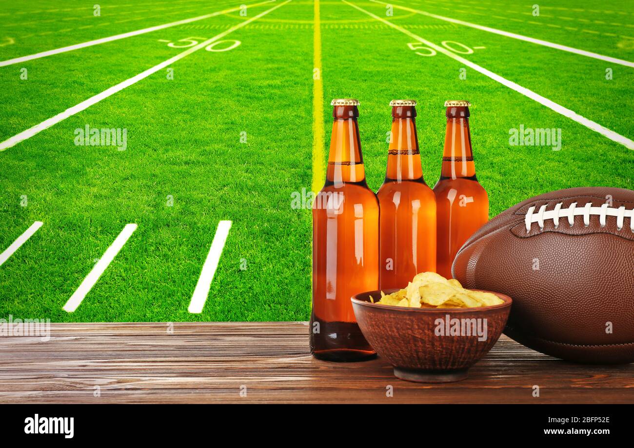 Beer bottles, ball and snack on football field background Stock Photo ...