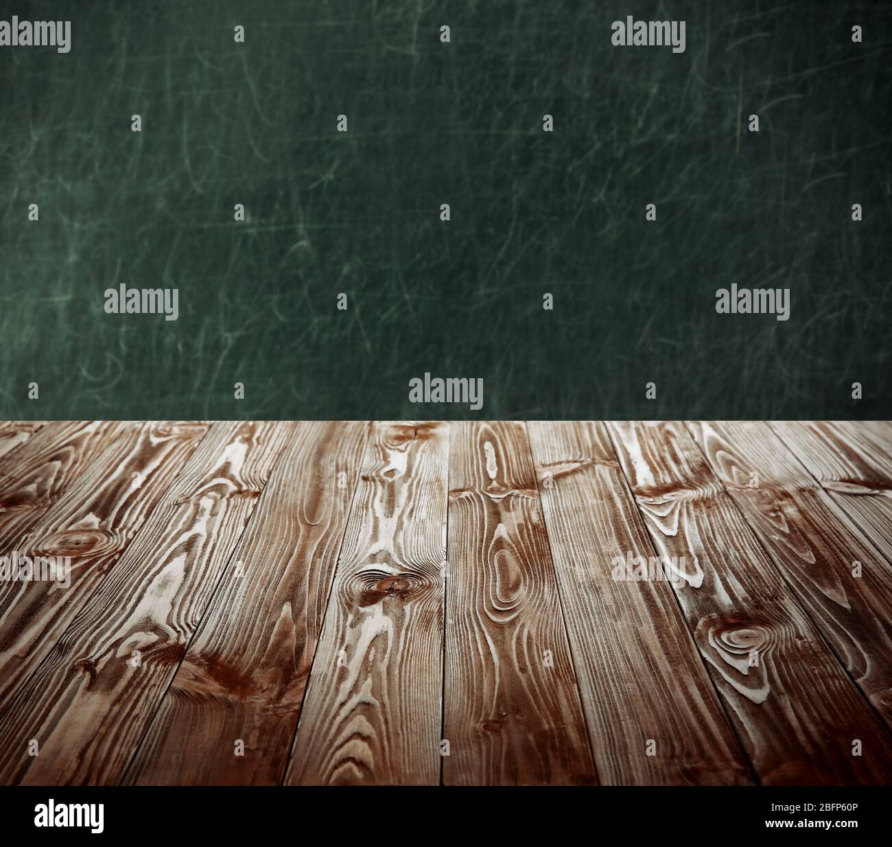 Wooden table on blackboard background. School concept Stock Photo - Alamy