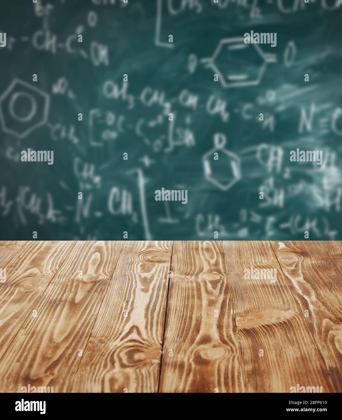 Wooden table on blackboard background. School concept Stock Photo - Alamy