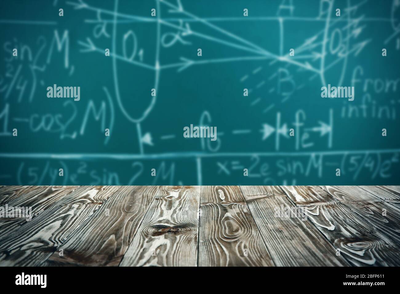 Wooden table on blackboard background. School concept Stock Photo - Alamy
