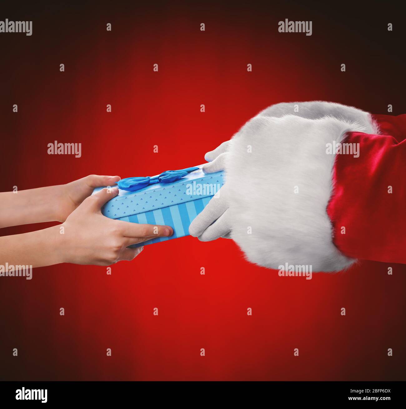 Santa hands give present to kid,on red background Stock Photo - Alamy