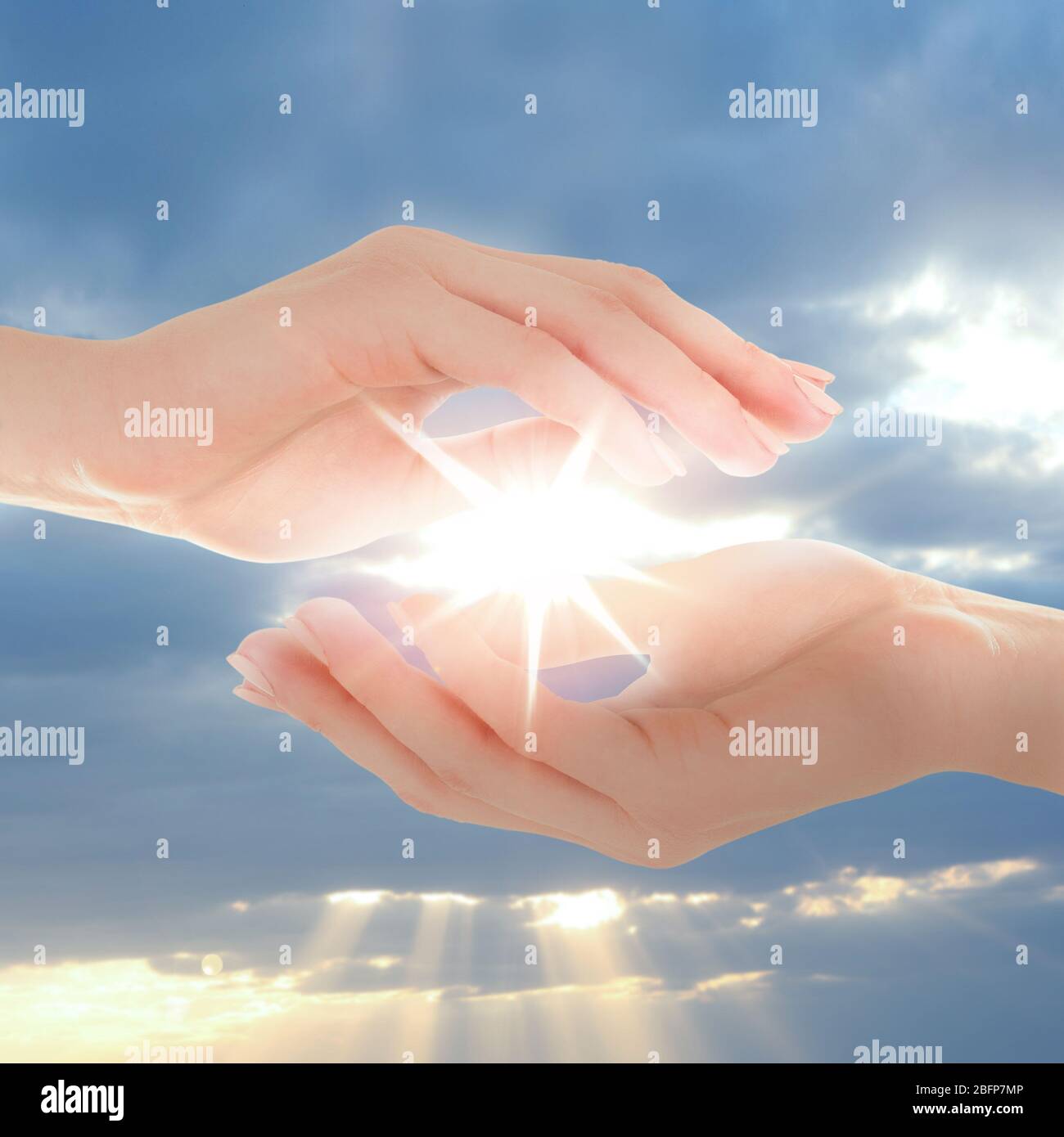 Female hands holding sunlight on sky background Stock Photo - Alamy