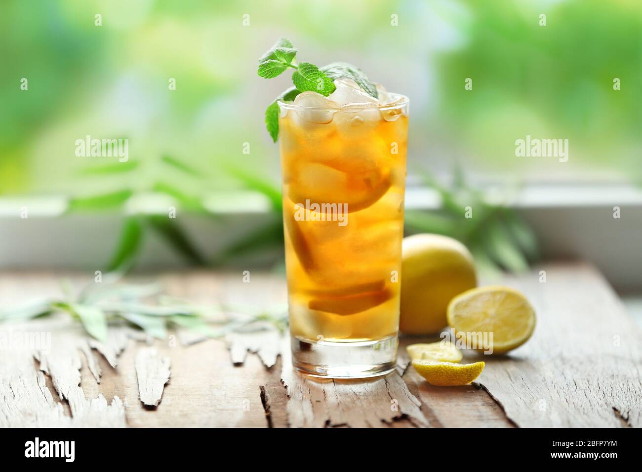 Glass of iced tea on wooden table and blurred green background Stock ...