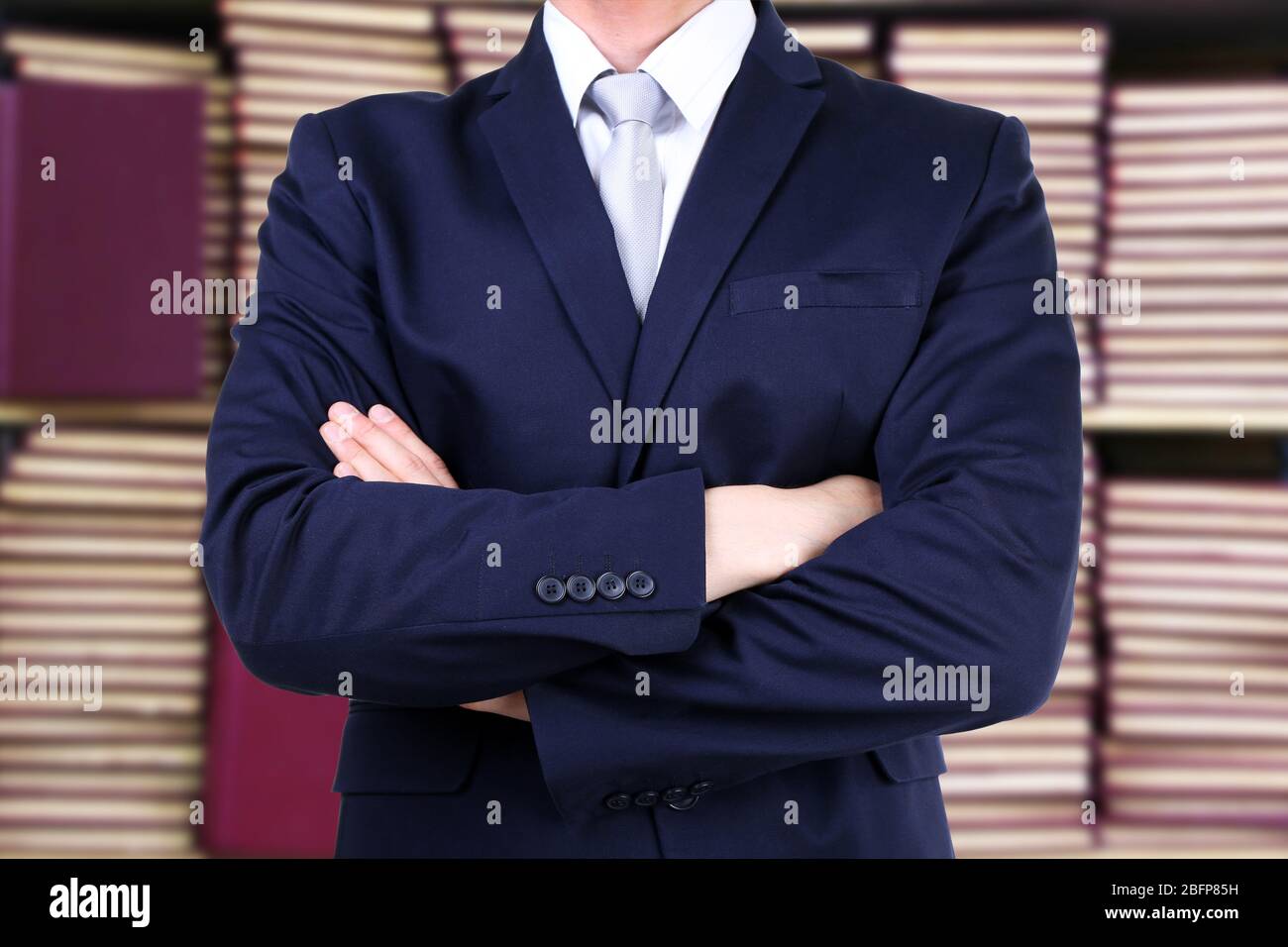 Businessman on blurred bookshelves background. Law concept Stock Photo ...