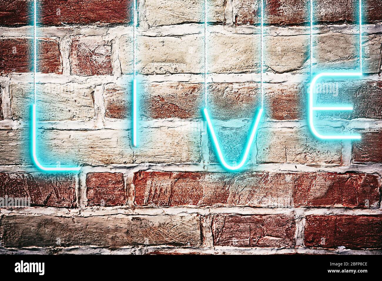 Neon text live on brick wall background Stock Photo - Alamy