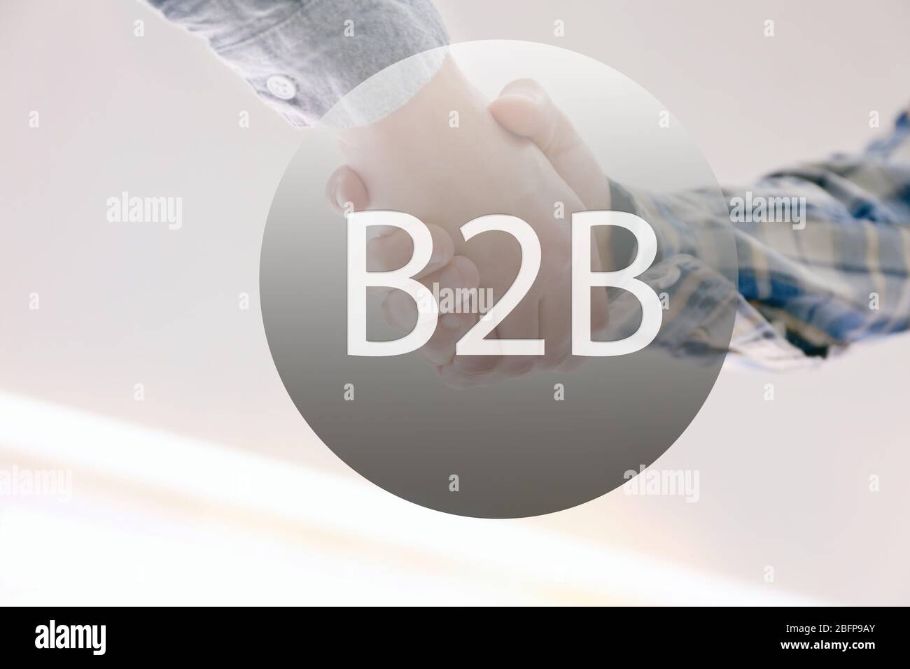 B2B business to business concept. Men shaking hands on light background ...