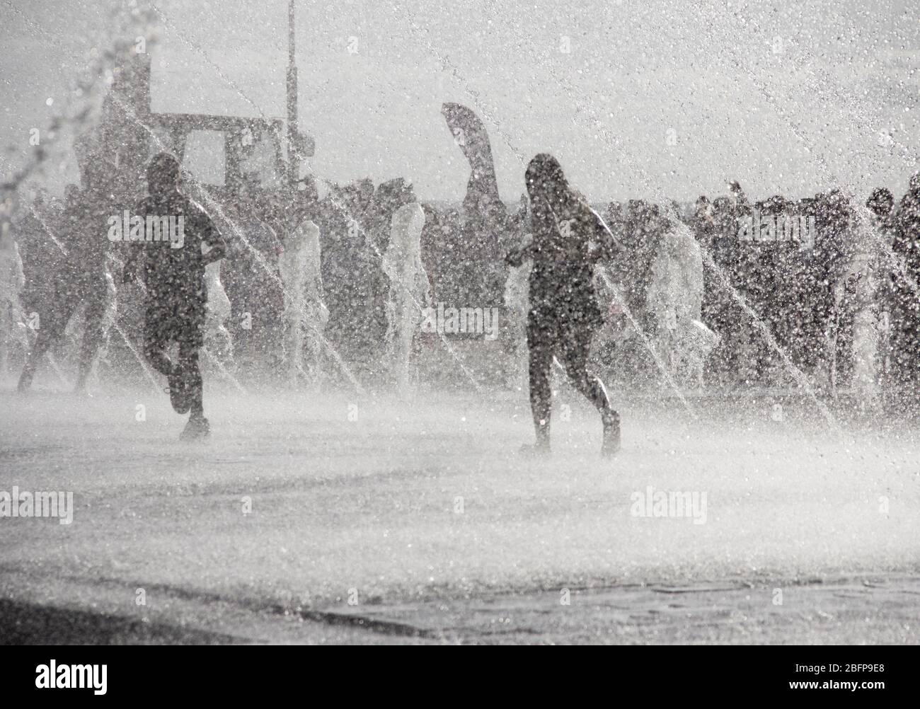 Silhouette of kids jumping in cool fountain water. A boy playing in ...