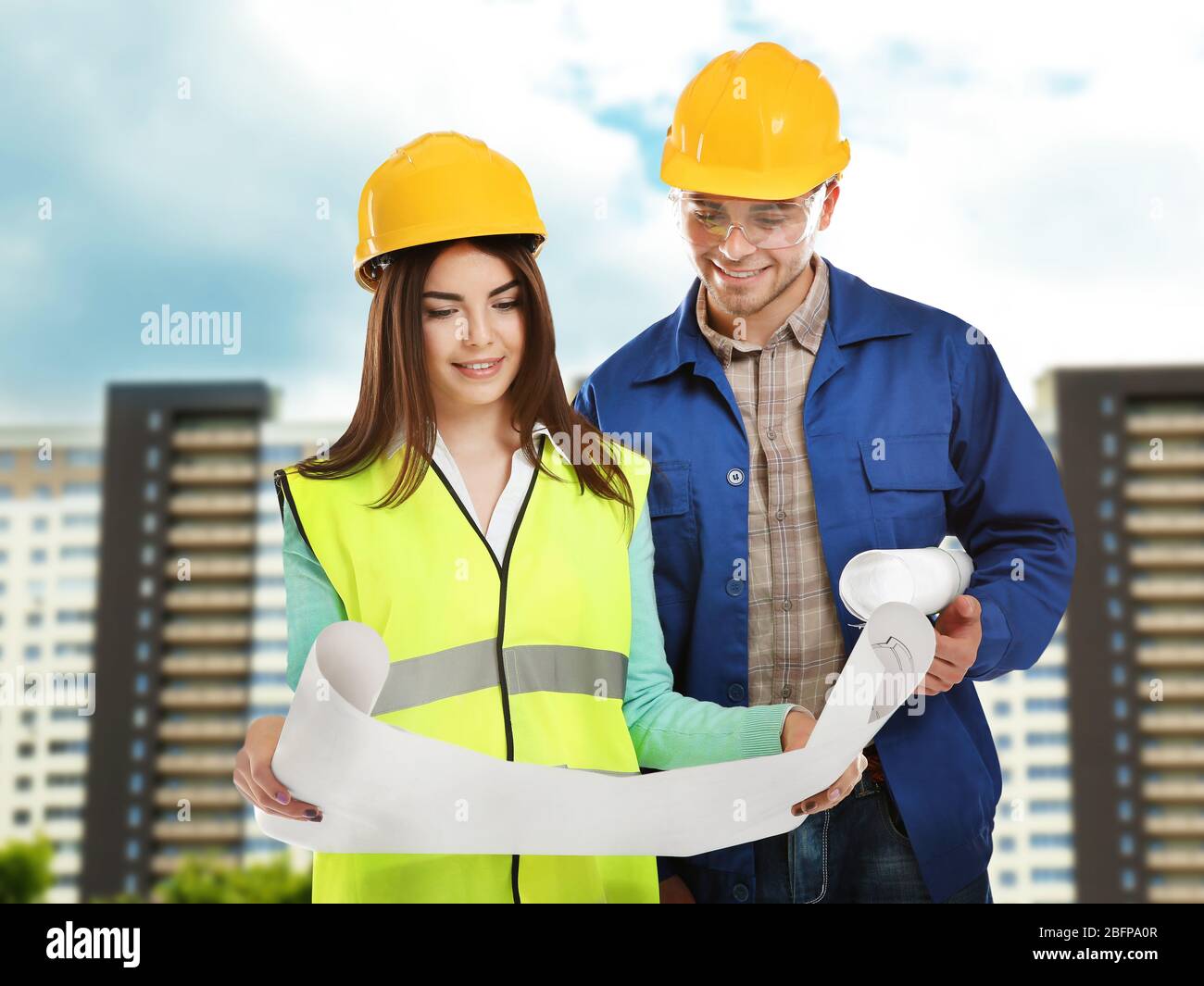 Man and woman in uniform with engineering blueprints on building ...