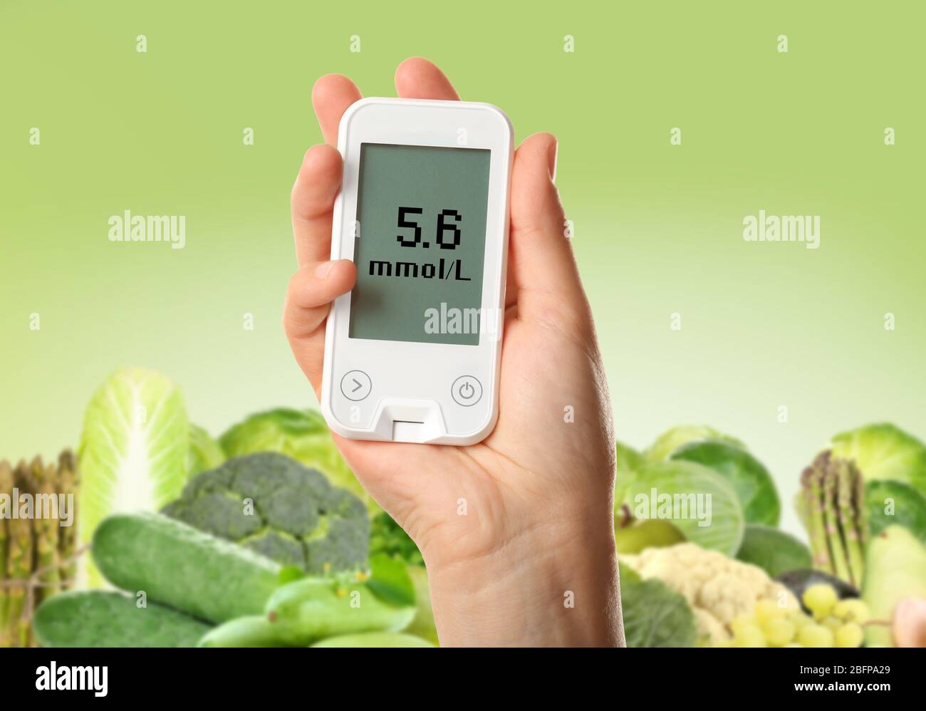 Male hand holding glucometer with vegetables and fruits on green ...