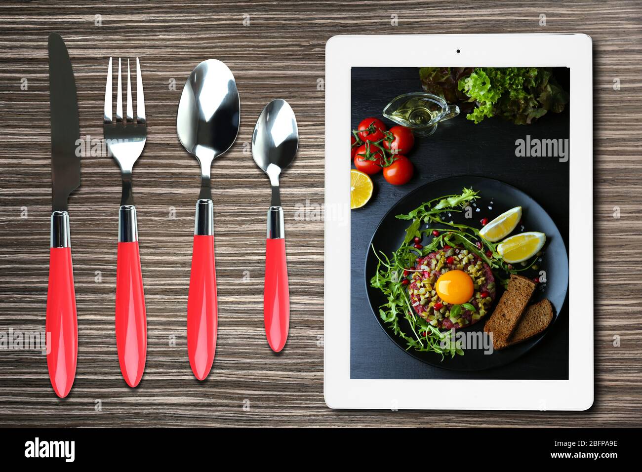 Table appointments and tablet. Photo of food on tablet screen Stock ...