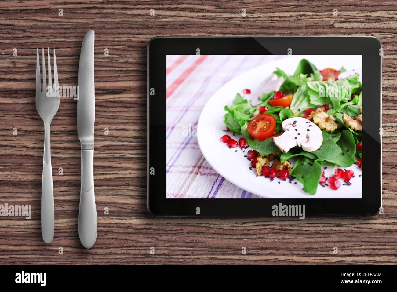 Table appointments and tablet. Photo of food on tablet screen Stock ...