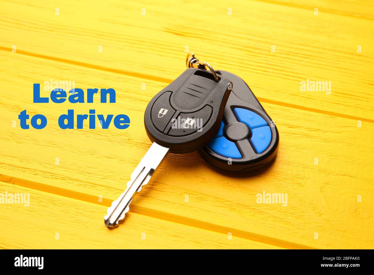 Learn to drive. Car key on yellow table Stock Photo - Alamy