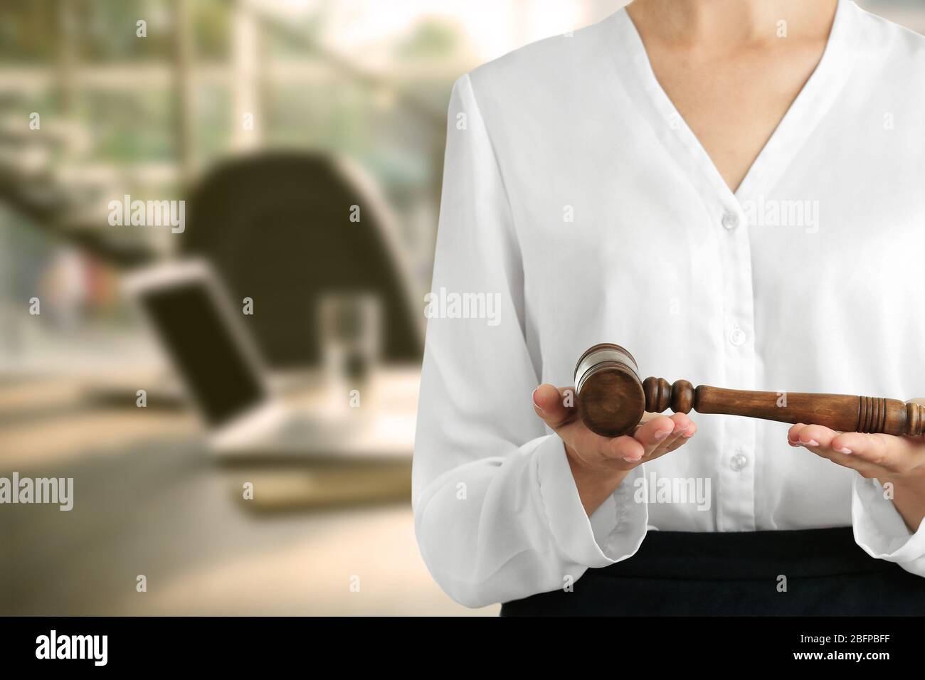 Female hands holding judge gavel on blurred office background. Justice ...