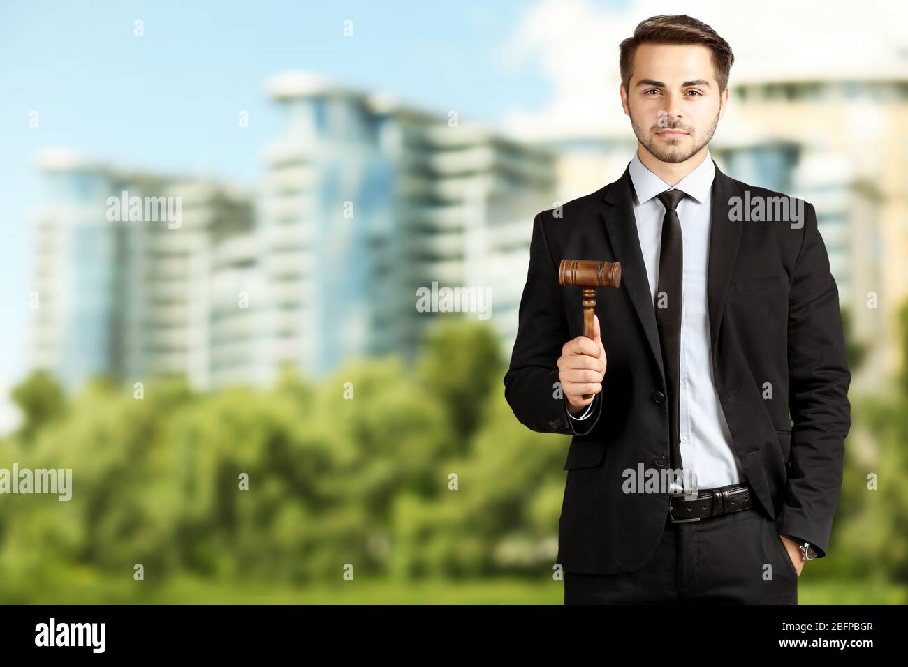 Handsome man judge gavel on blurred building background. Justice ...