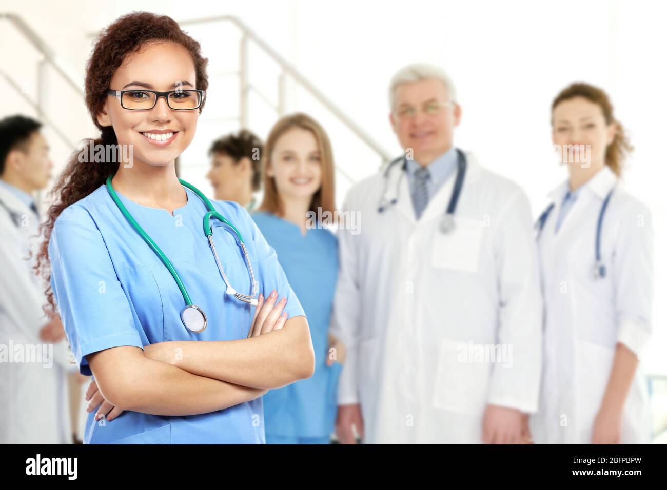 Young doctor and medical team on blurred hospital background. Health ...