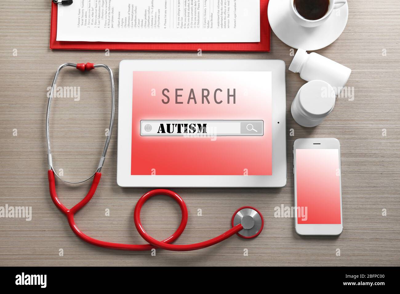 Red stethoscope with tablet and accessories on wooden table. Children ...