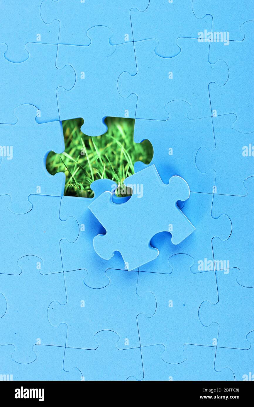 Blue puzzle with missing piece over green grass background Stock Photo ...